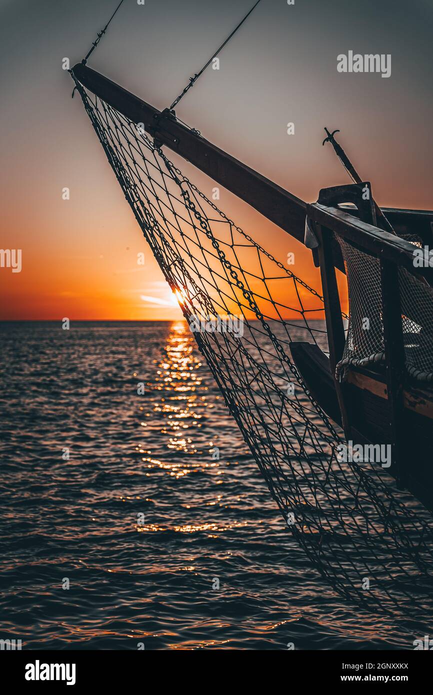 Vertical shot of a fishing net hanging from a ship's bow in Rovinj ...