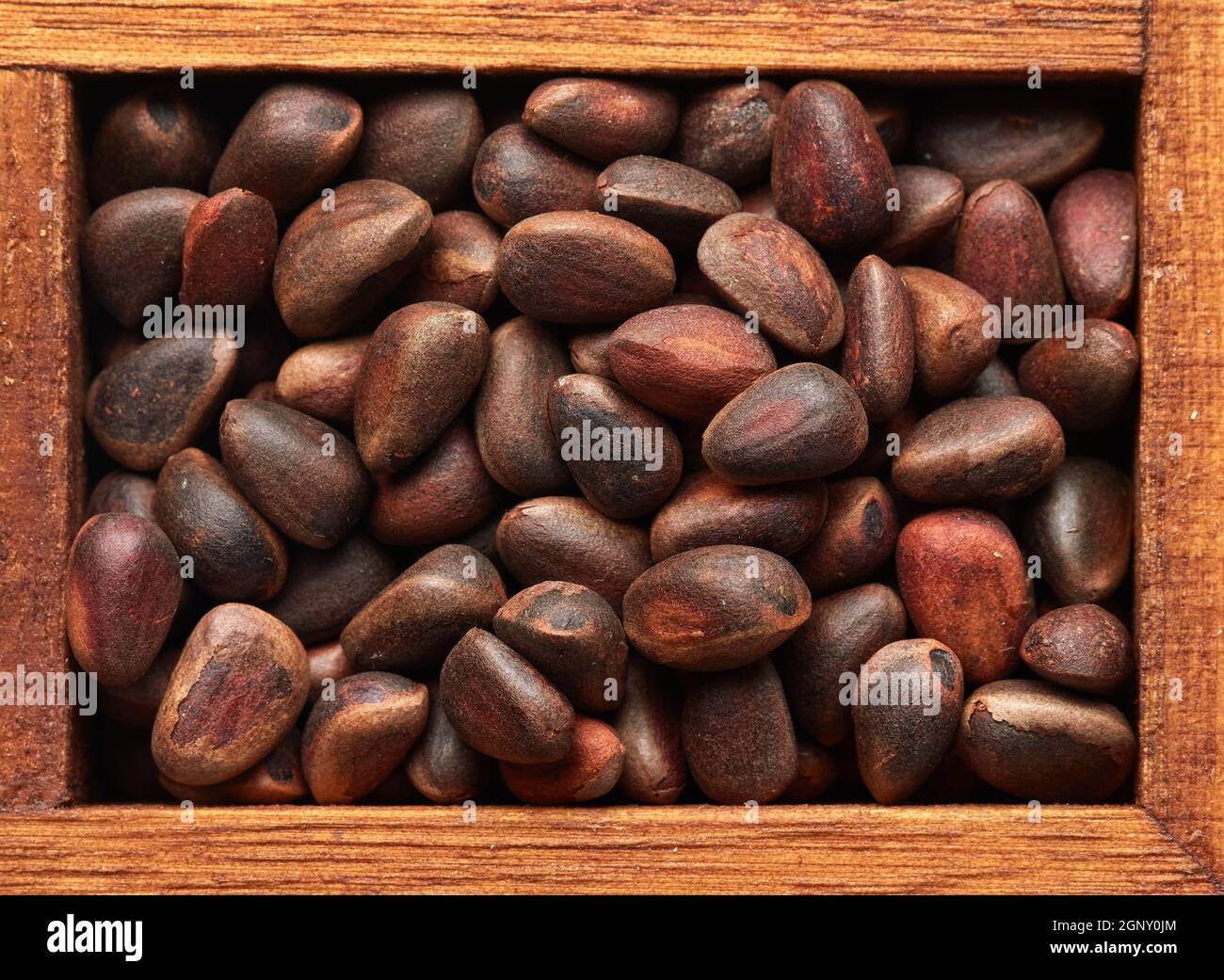 Pine nuts in wooden box on brown wood background. Pinus sibirica ...