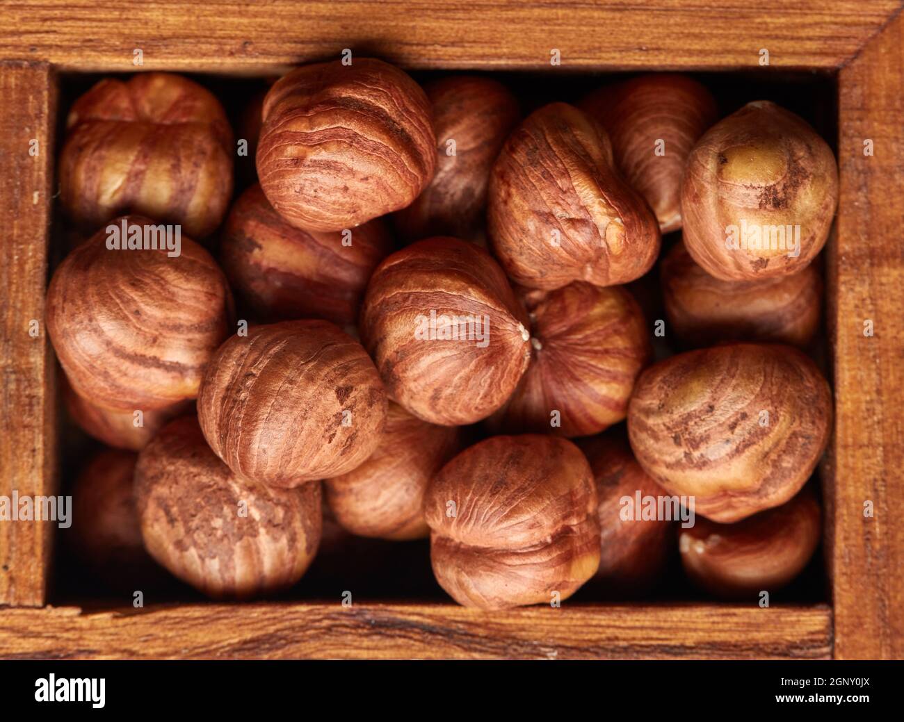 Hazelnuts in wooden box on brown wood background. Top view. Filbert ...