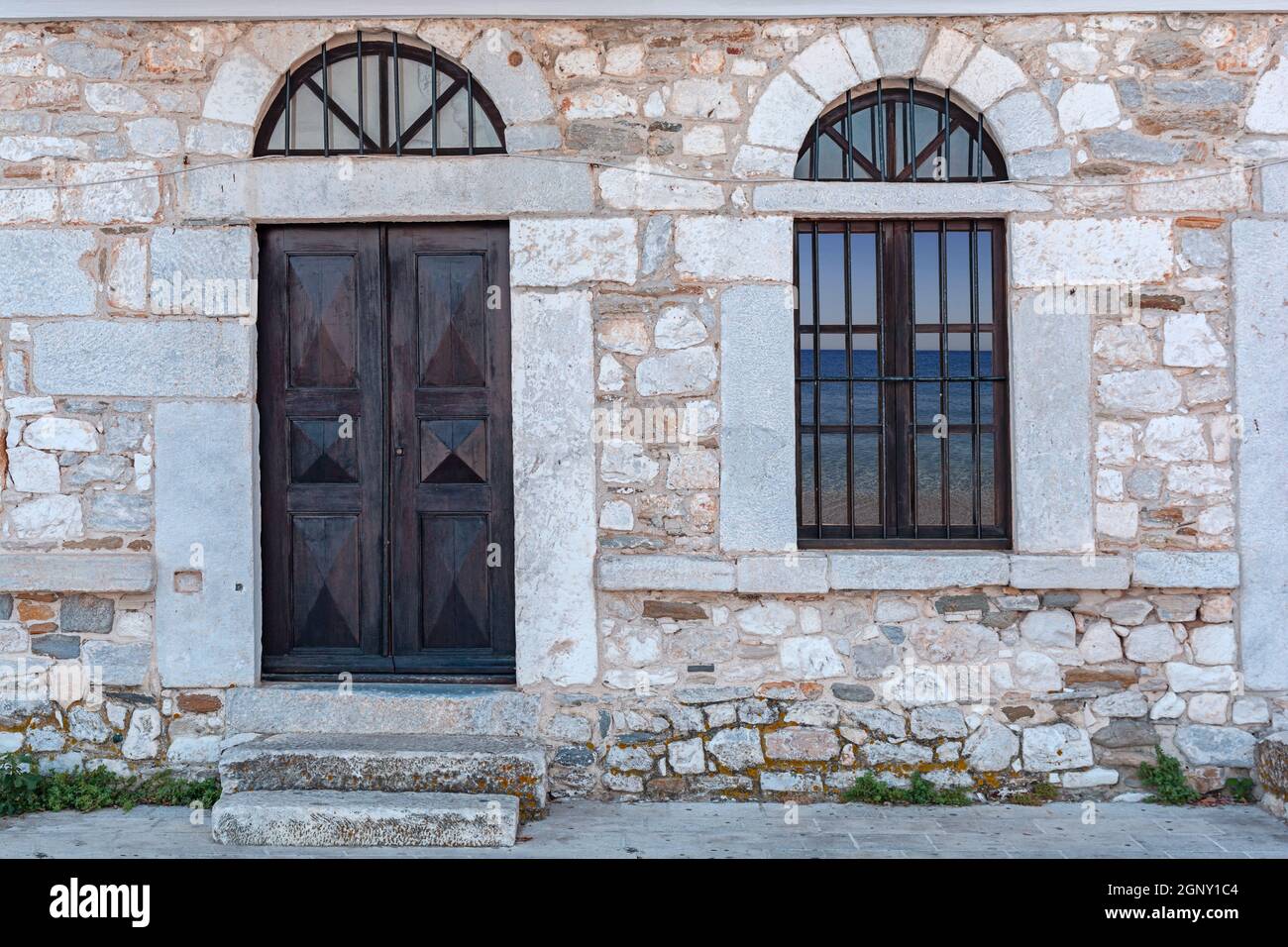 Old architecture stone house with black wooden door and window ...