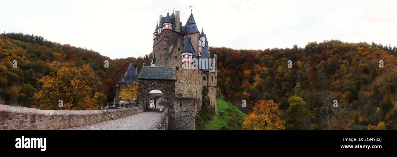 Pano of Eltz castle and surrounding hills covered in colorful trees in ...