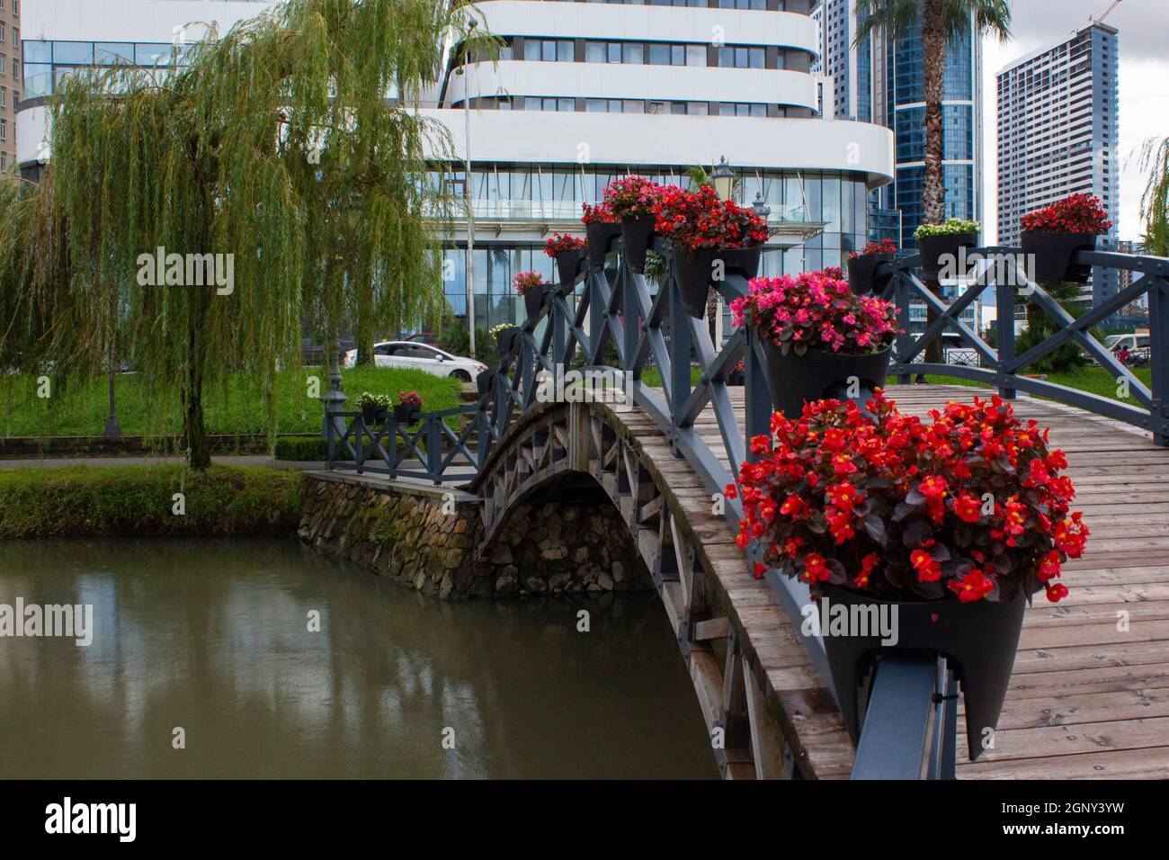 Beautiful flowers growing in pots on an arched bridge over a water ...