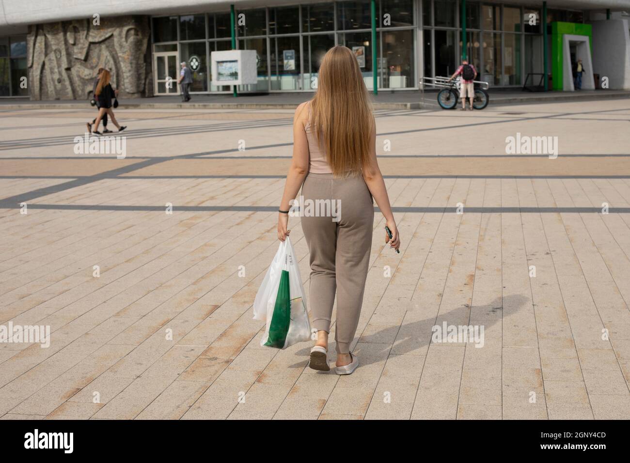 The girl walks through the square. A woman with a beautiful appearance ...