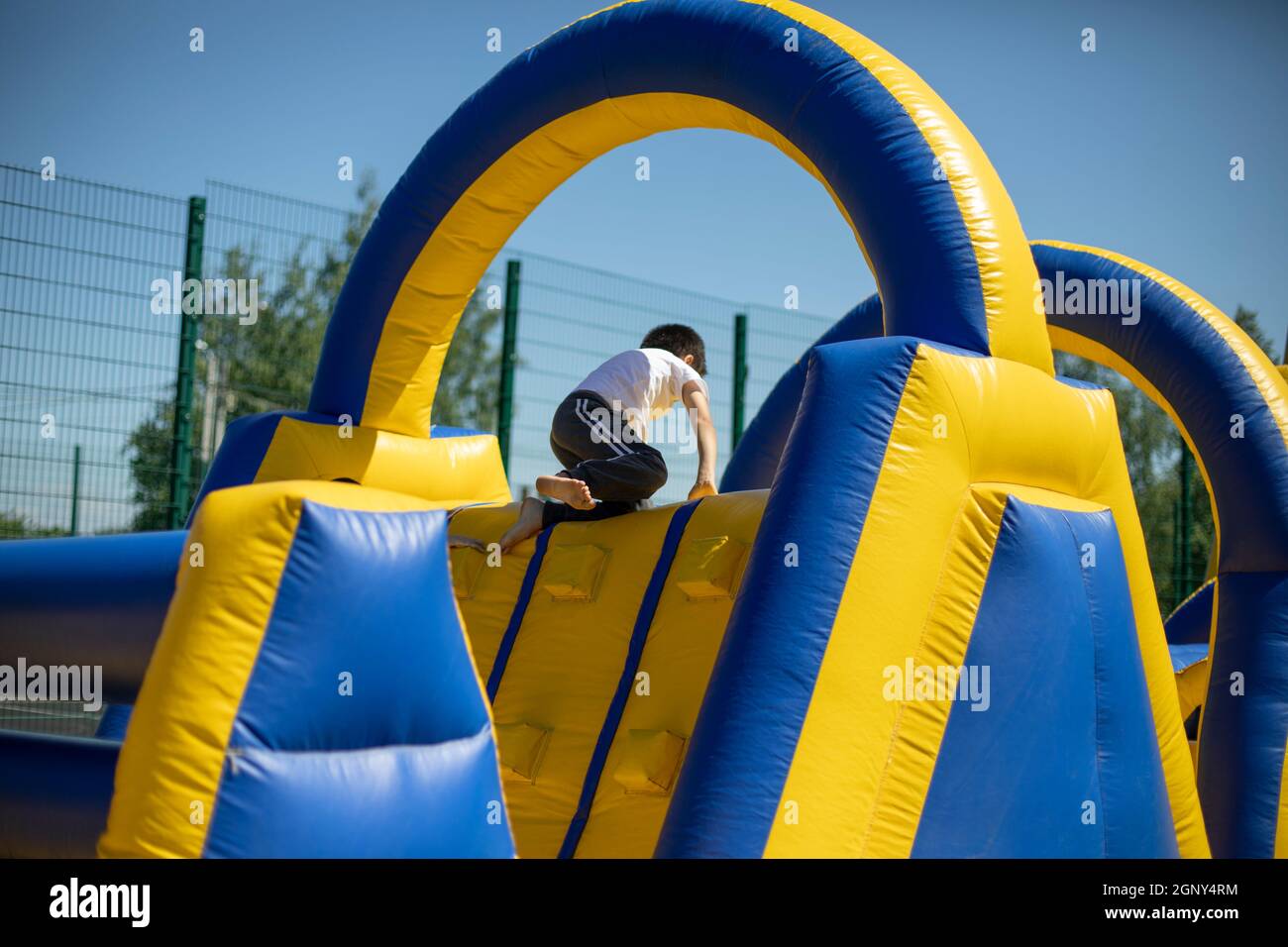 Children climb an inflatable slide. Inflatable obstacle course for fun ...