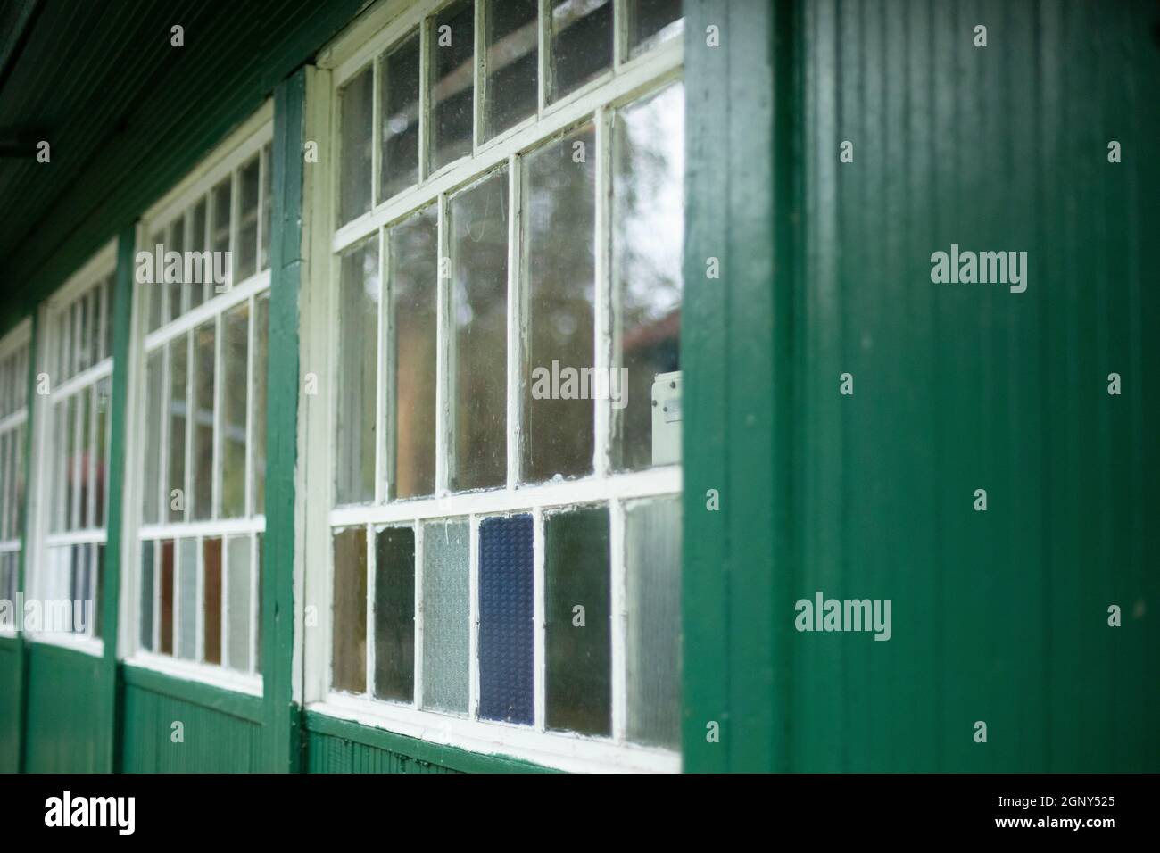 An old window in the village. Colored glass in the window frame. Facade ...