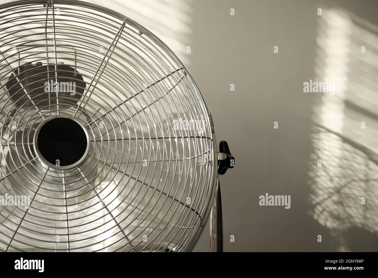 Closeup part of electric fan standing in the room against white wall ...