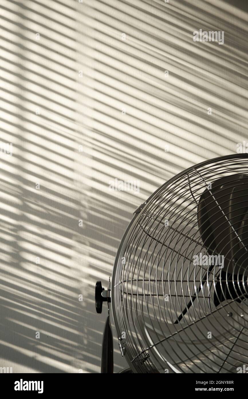 Closeup part of electric fan standing in the room against white wall ...