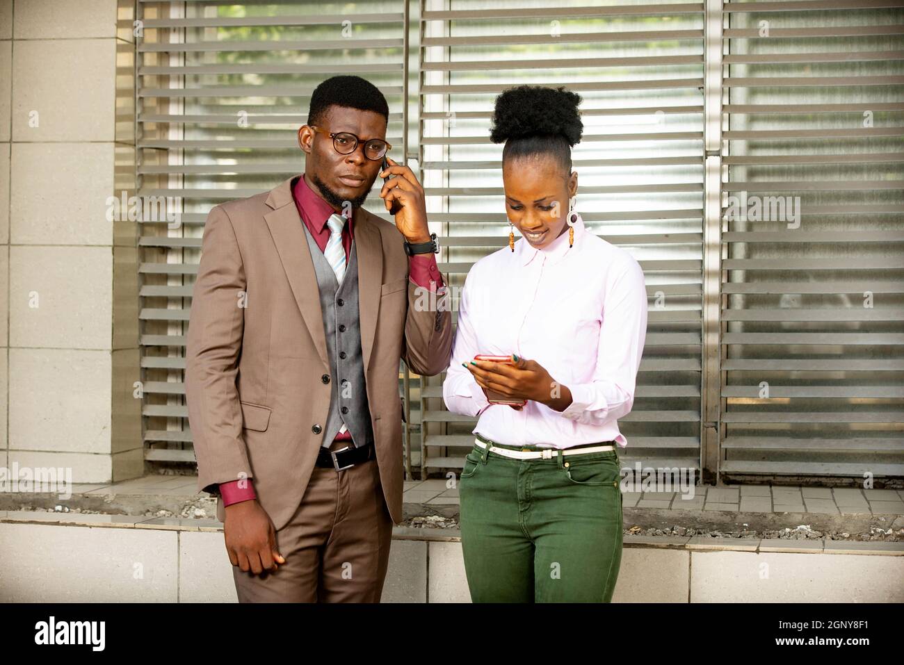 Two attractive smart partners make important calls outside their ...