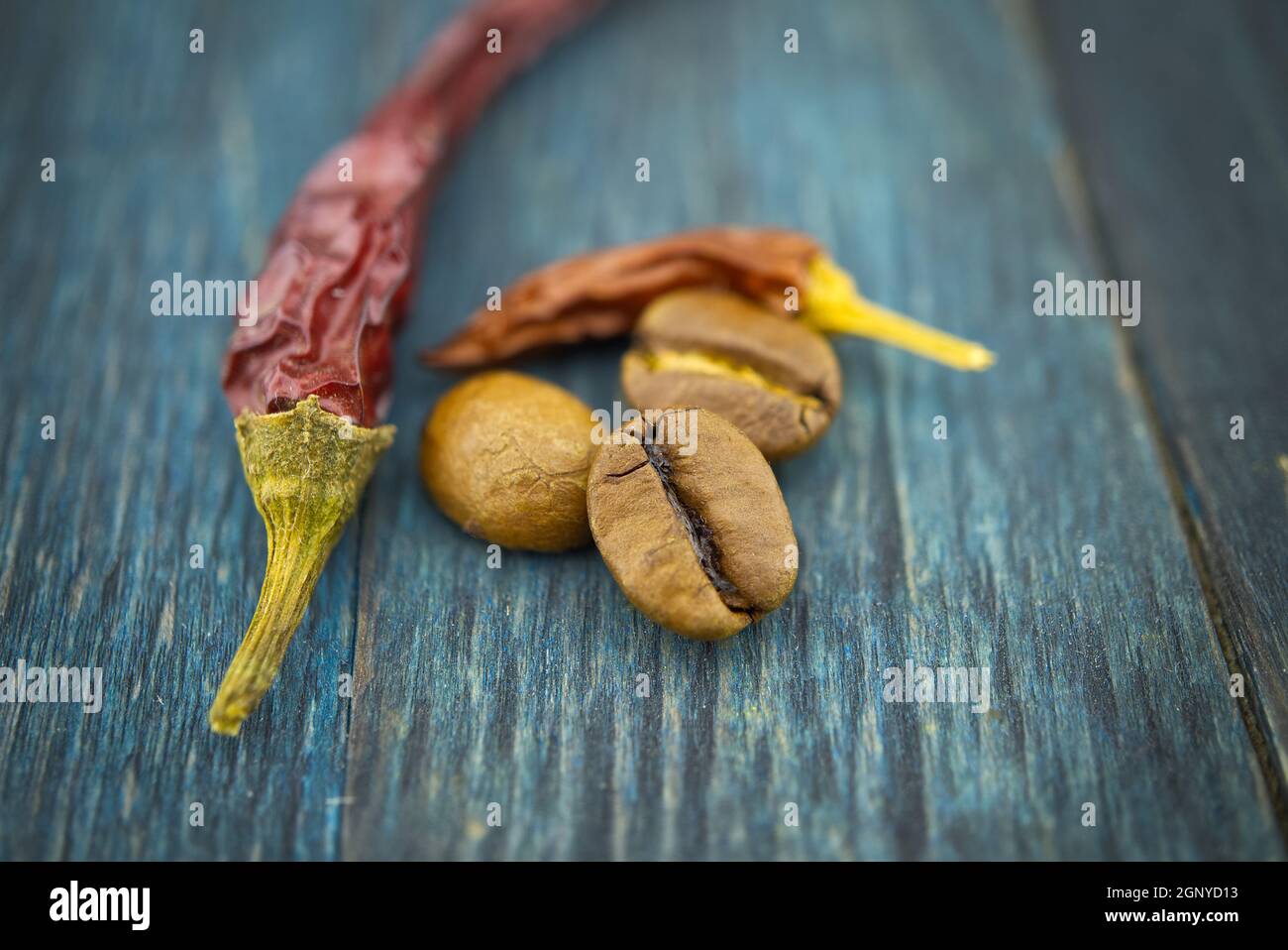 Dried red chili pepper and roasted coffee beans on wooden background ...
