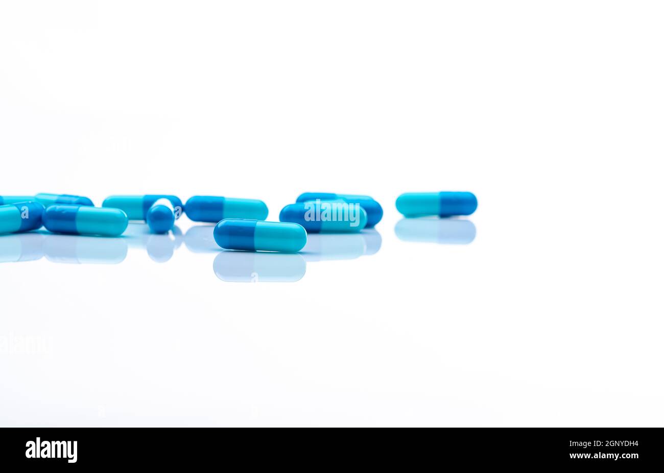 Selective focus on blue and white capsules pill on white background ...