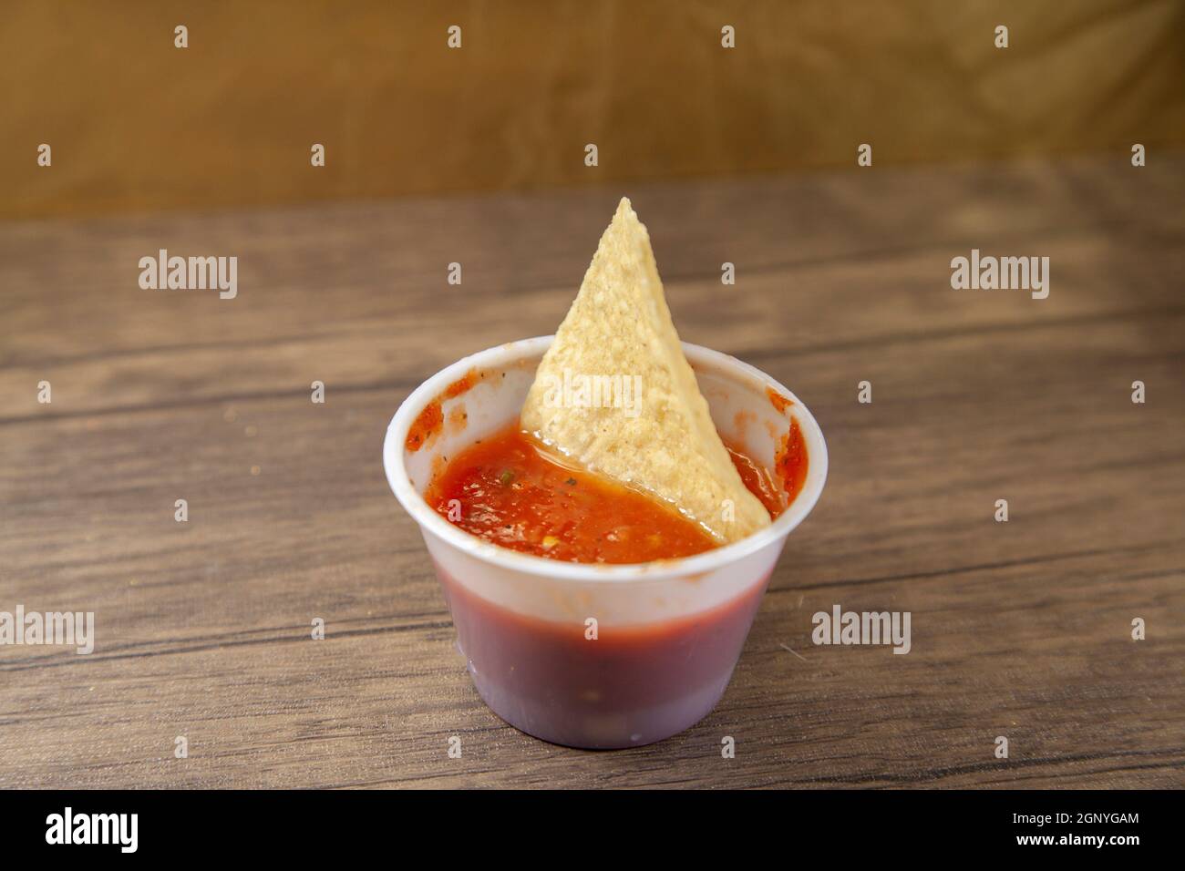 Single tortilla chip in a cup of salsa Stock Photo - Alamy