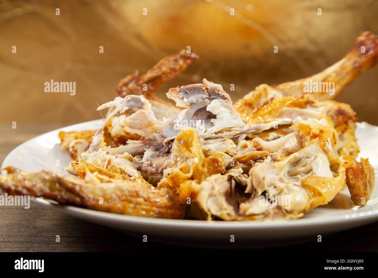 Remains of roasted chicken bones and meat that have been eaten off of ...