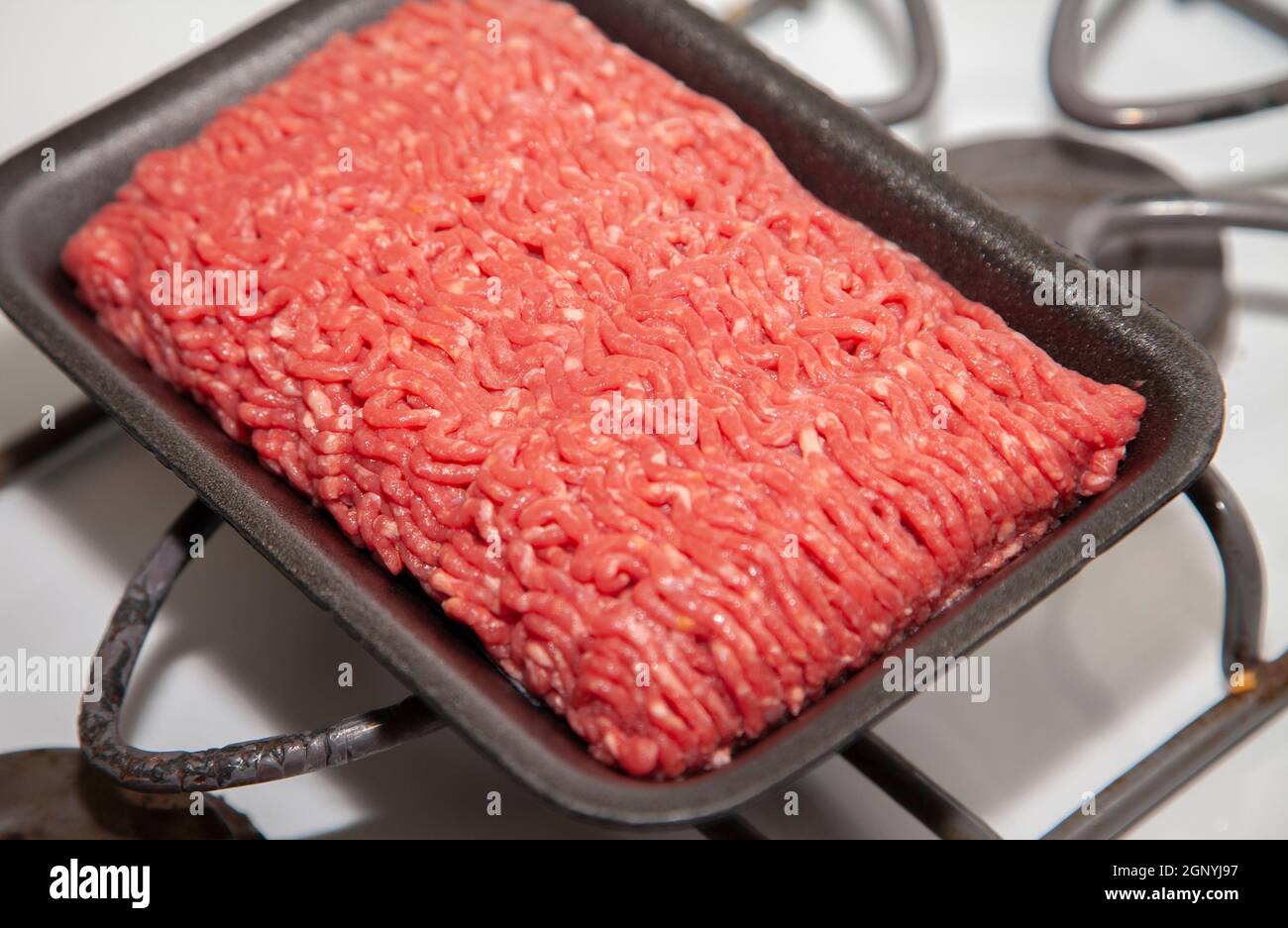 One open package of ground angus beef on a stove Stock Photo - Alamy