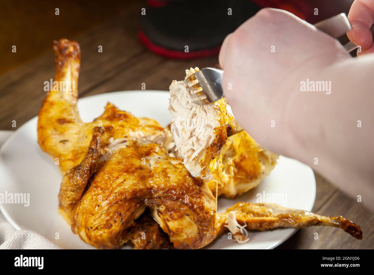 Woman pulling a piece of chicken from a whole roasted chicken Stock ...