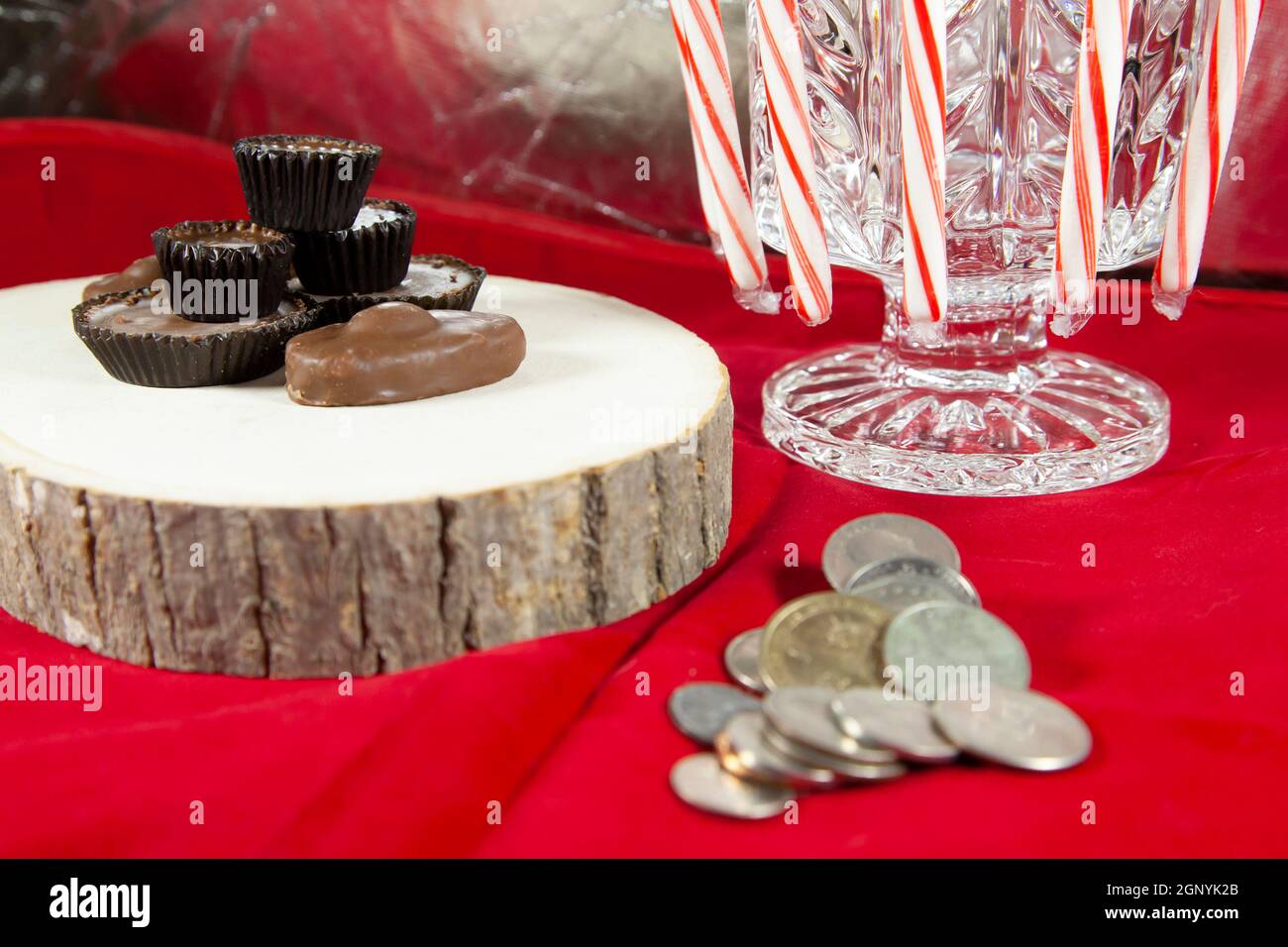 Penny, nickel, dime, quarter, and dollar coins on a red tabletop with ...