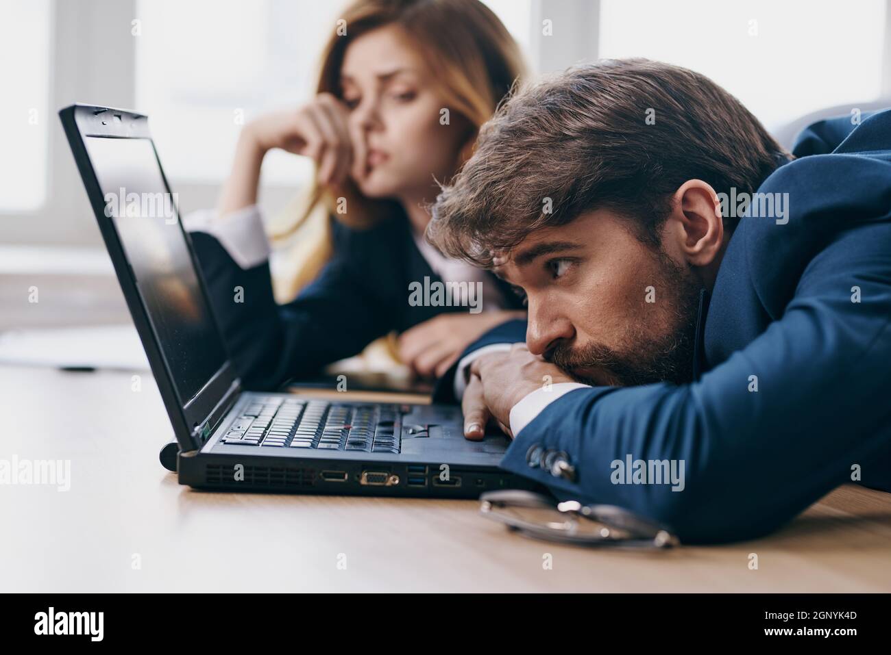 colleagues in the office in front of a laptop career work officials ...