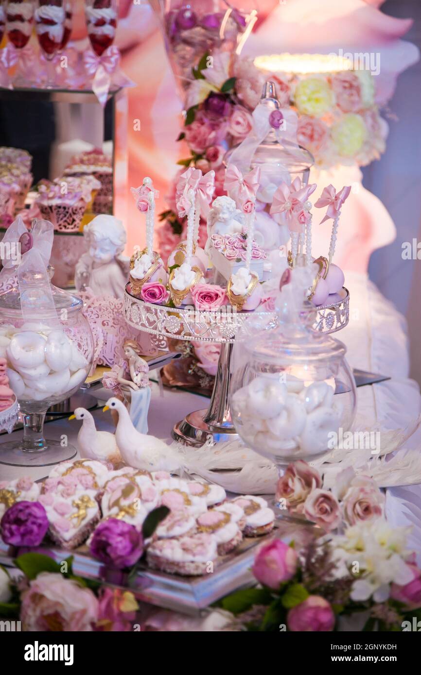 Delicious desserts at the wedding candy bar in the buffet area: cake pops decorated with angels ...