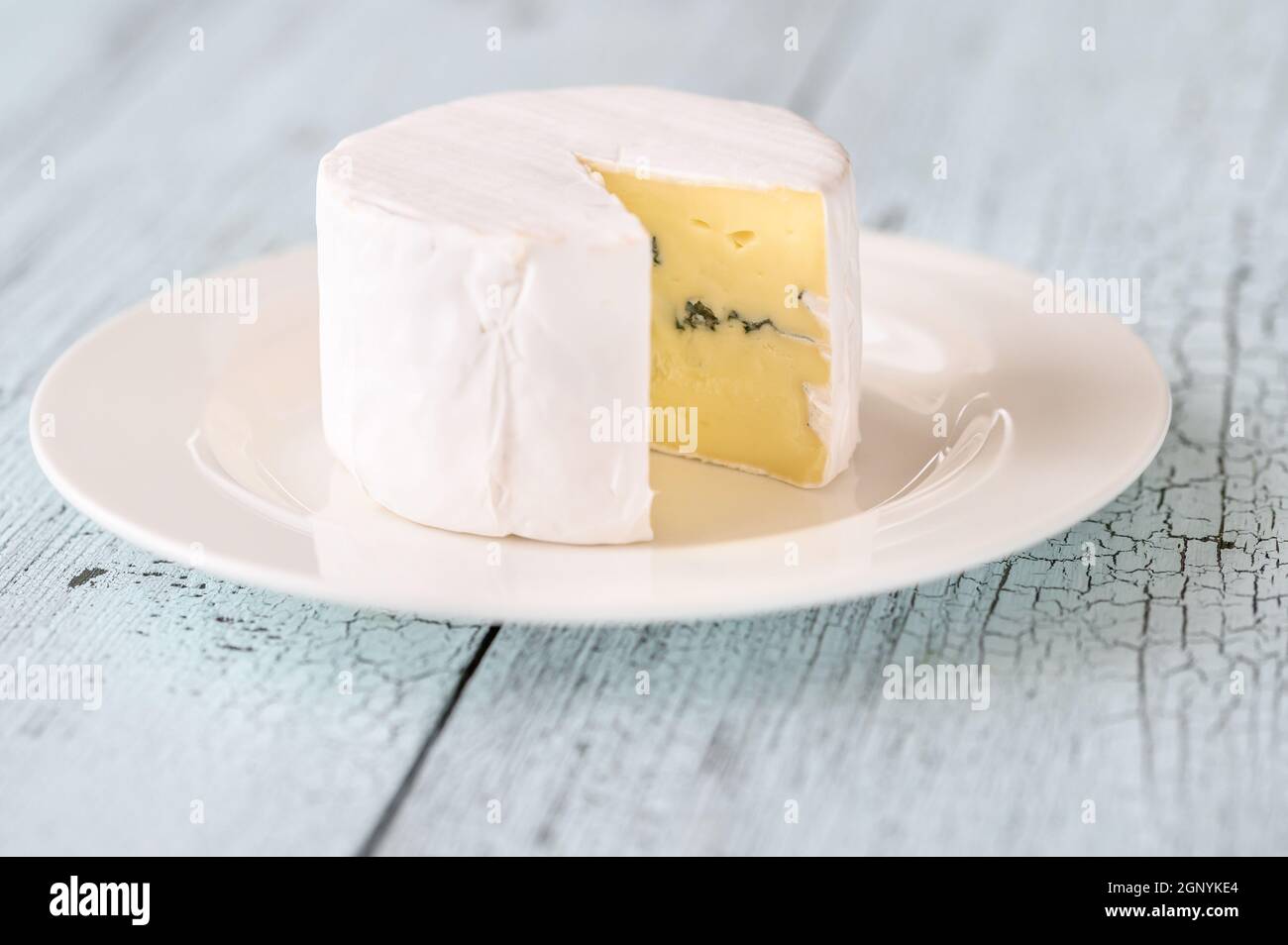 Blue cheese under a rind of white mould on the plate Stock Photo - Alamy