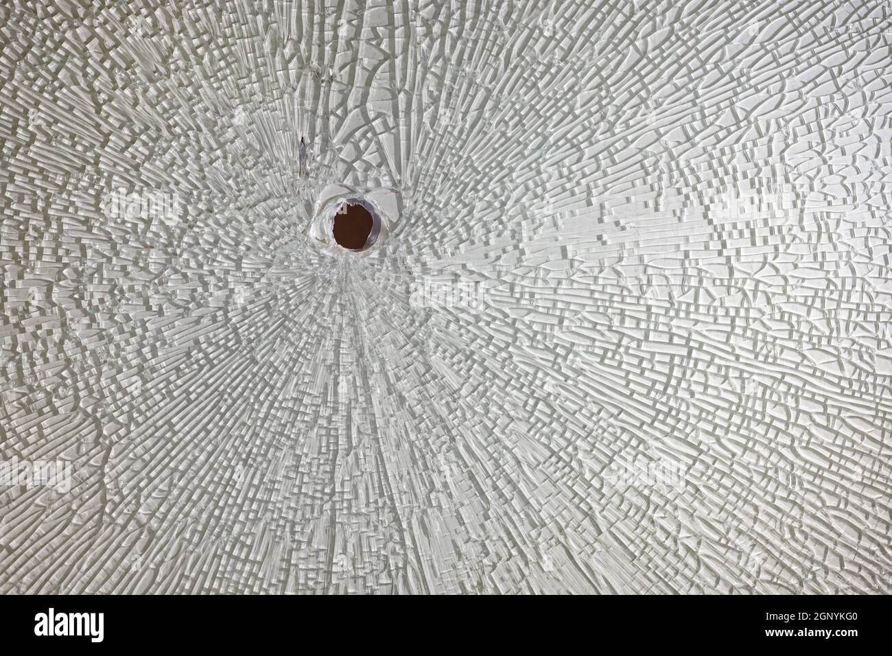 Cracks around the hole in the broken tempered glass Stock Photo - Alamy