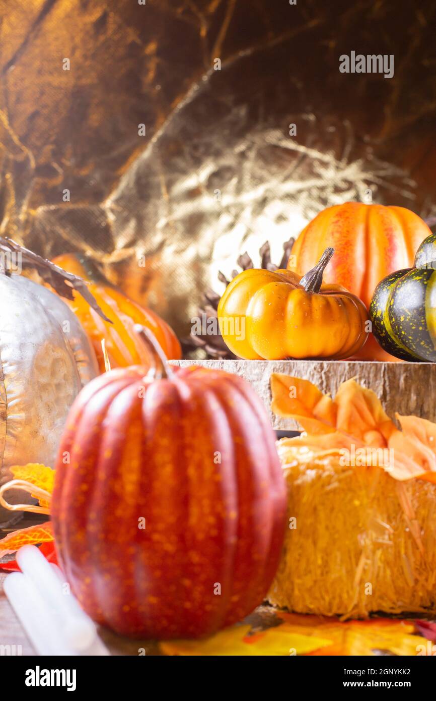 Small red pumpkin next to hay covered with leaves, orange pumpkins ...