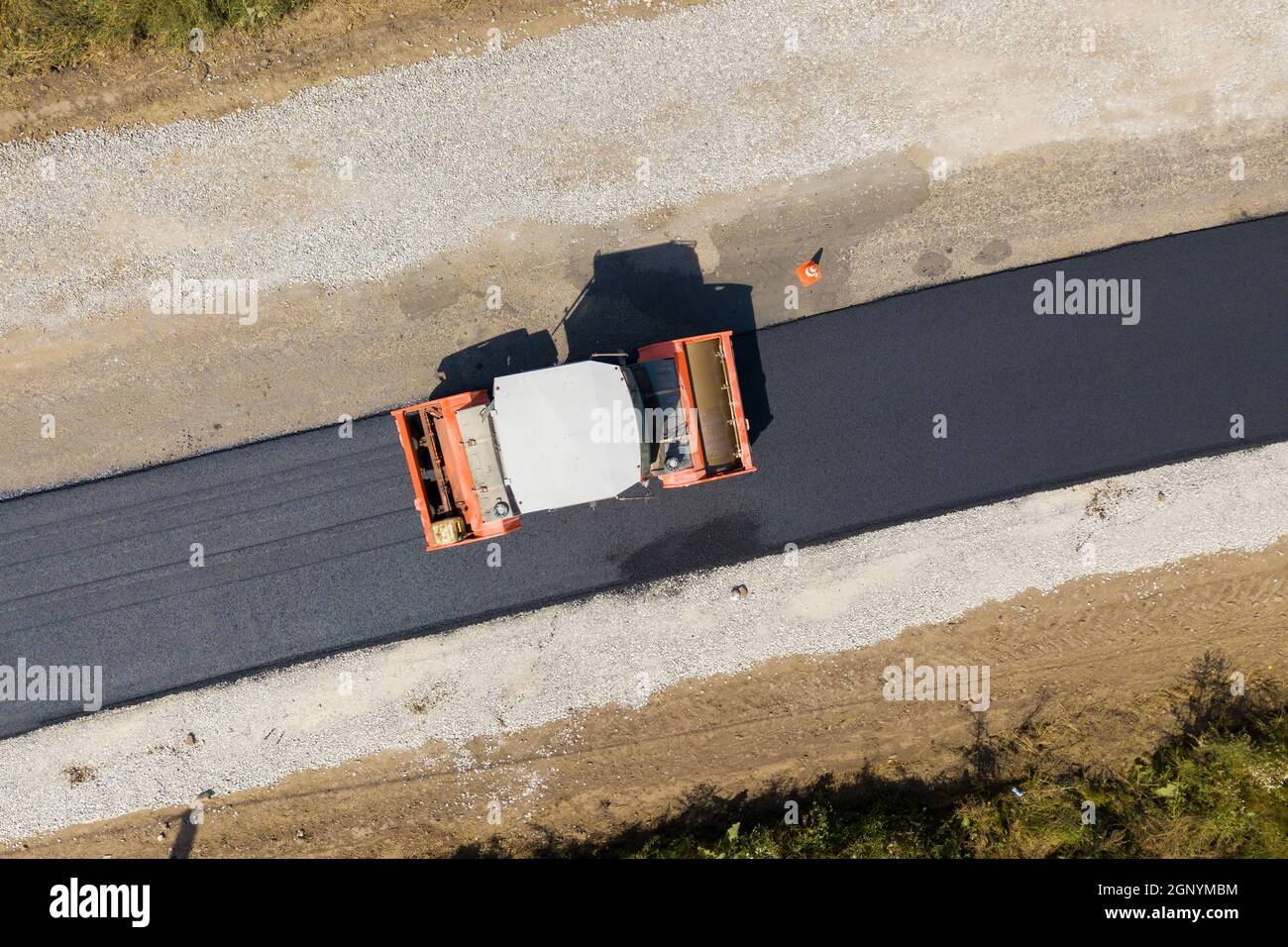 Aerial view of new road construction with steam roller machine at work ...