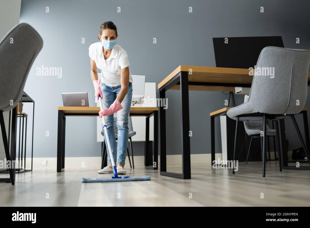 Female Janitor Mopping Floor In Face Mask In Office Stock Photo - Alamy