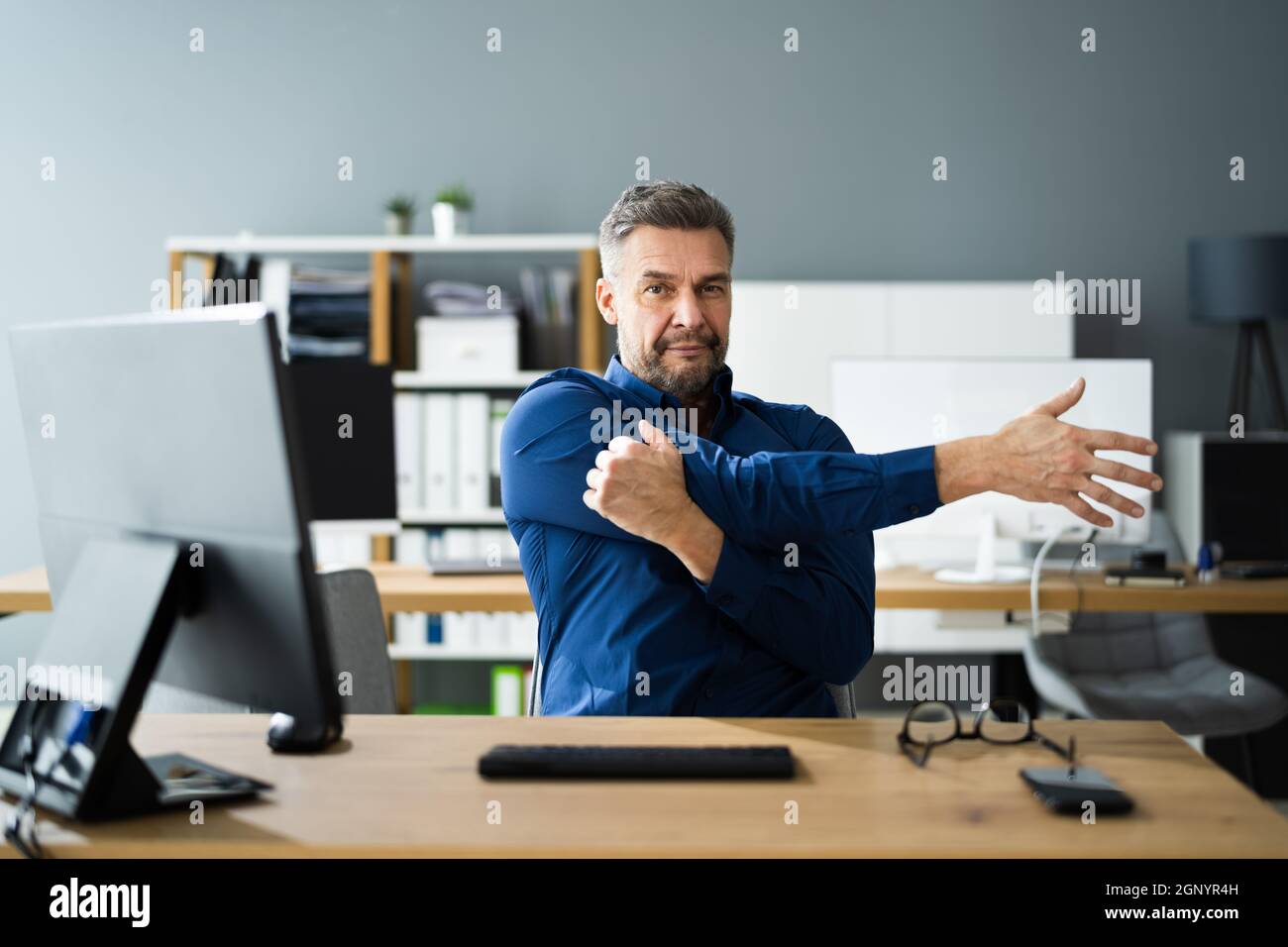 Stretch Exercise At Office Desk At Work. Stress Break Stock Photo - Alamy