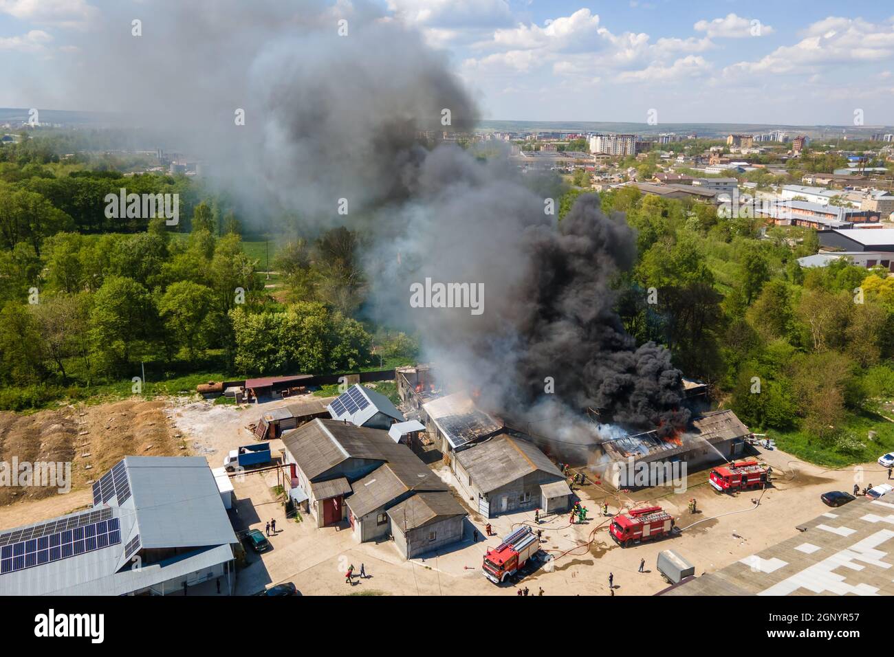 Aerial view of firefighters extinguishing ruined building on fire with ...