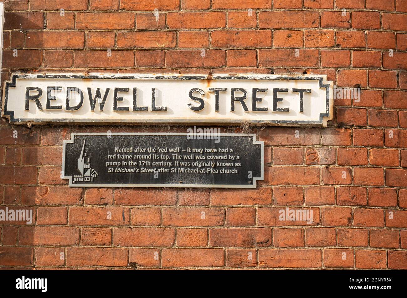 An original cast iron street name with an infomation plaque below on a ...
