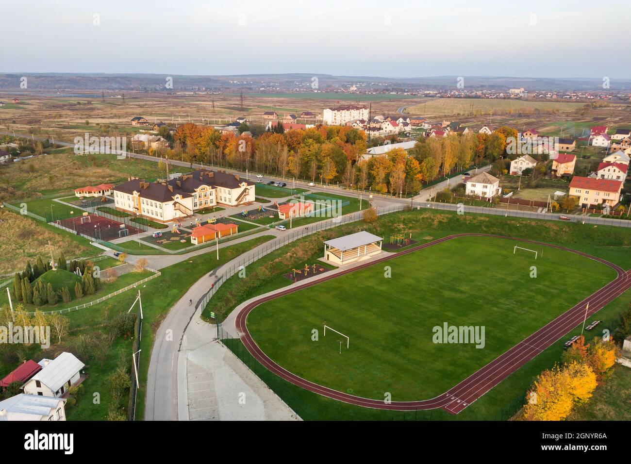 Aerial view of sports stadium with red running tracks and green grass ...