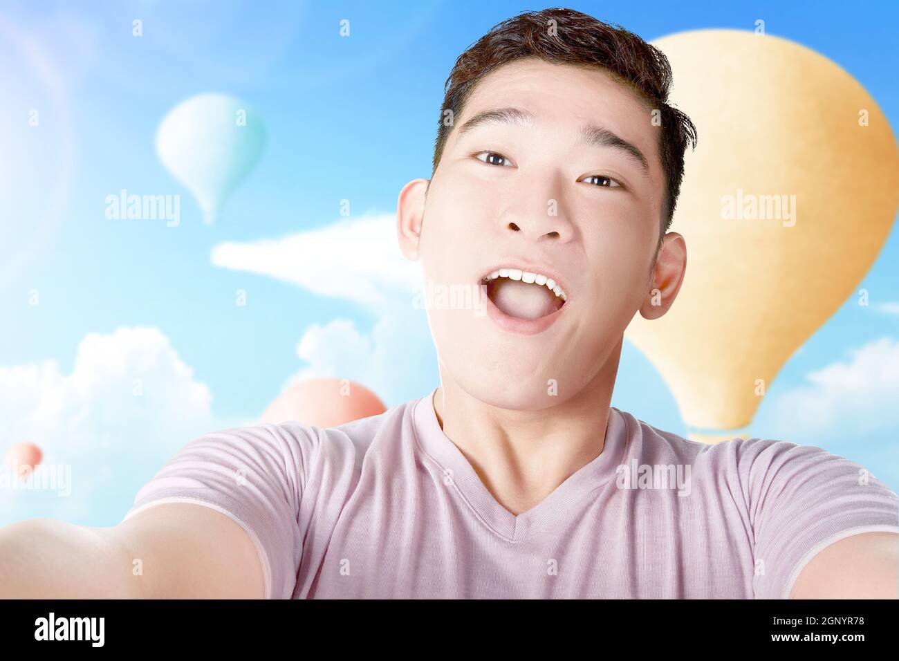 Asian man taking a selfie with colorful air balloon flying with blue ...