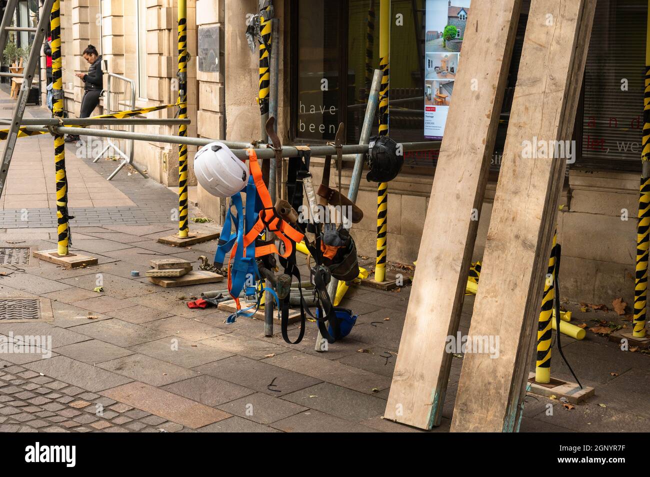 Scaffolding on a building with safety harnesses and hard hats hanging ...