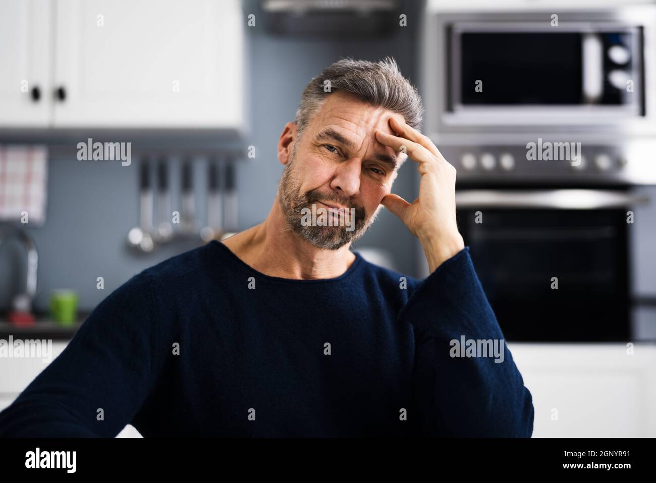 Depressed Sad Man With Headache Sitting At Home Stock Photo - Alamy