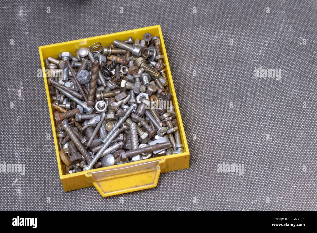 Yellow old box with several screws Stock Photo - Alamy