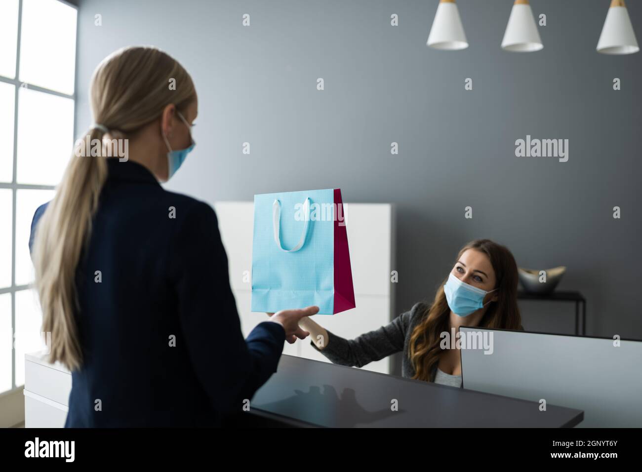 Cashier In Retail Shop Or Store At Counter Wearing Face Mask Stock ...