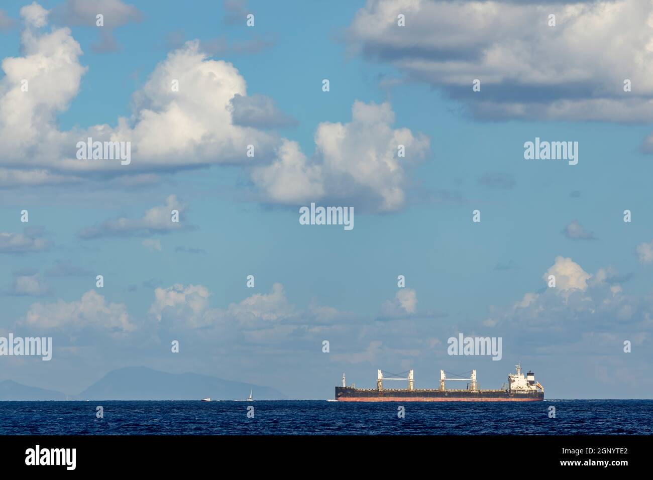 cargo ship nearby Capo Peloro Lighthouse in Punta del Faro on the ...