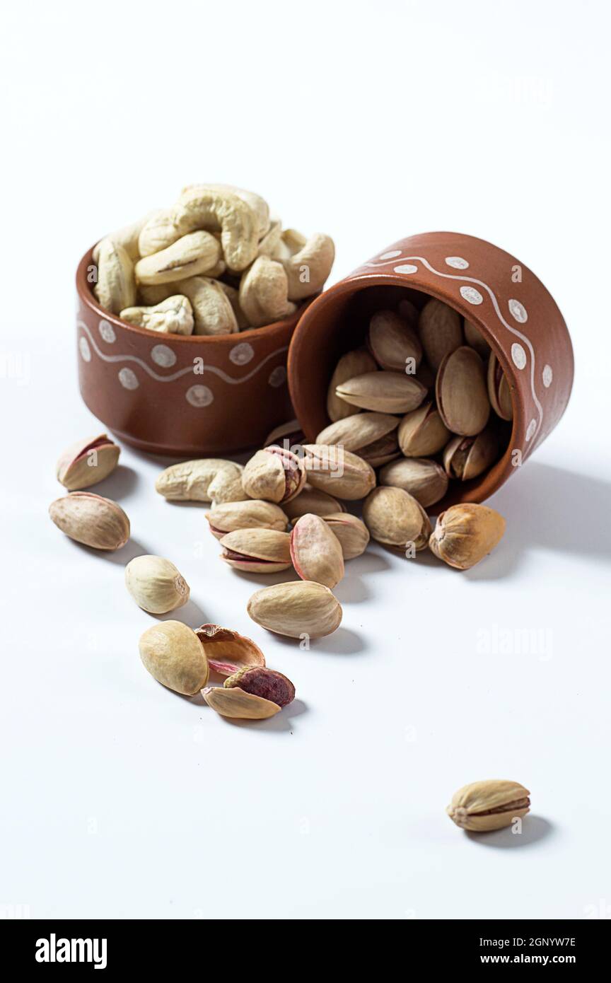 Pistachio and Cashew Nuts in clay pots on white background Stock Photo ...