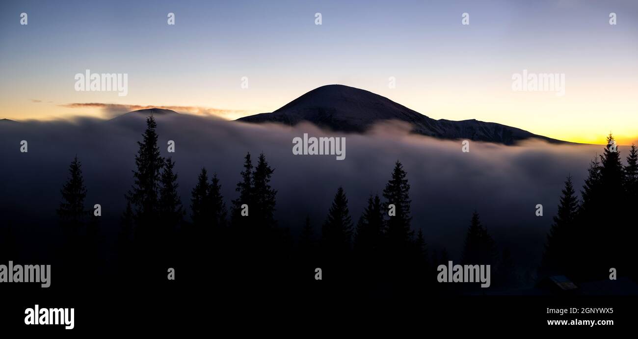 Beautiful mountain landscape with hazy peaks and foggy wooded valley at ...