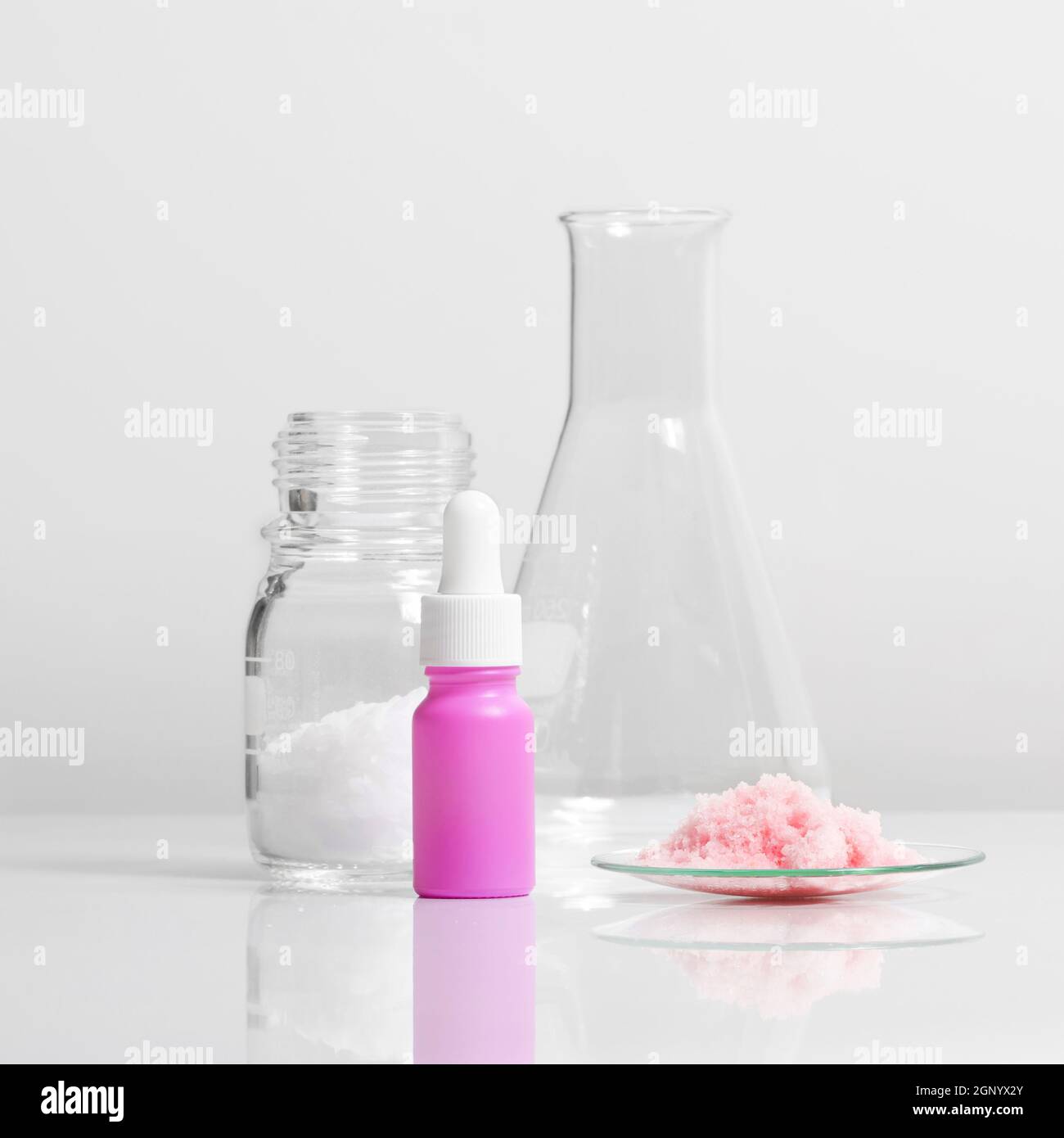 Chemicals for beauty care on white laboratory table. Pink flake ...