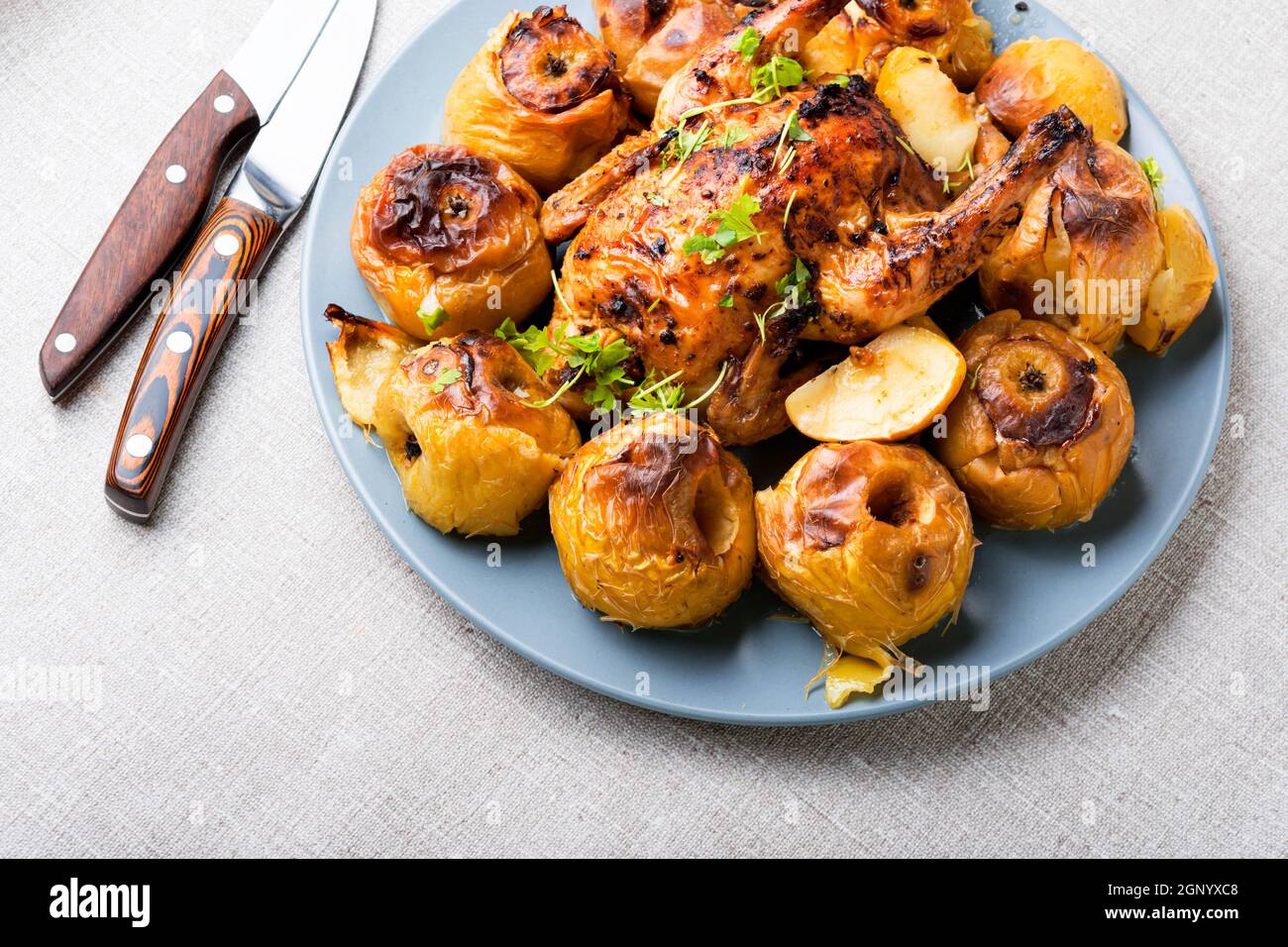 Homemade whole chicken or partridge baked with apples on a plate Stock ...