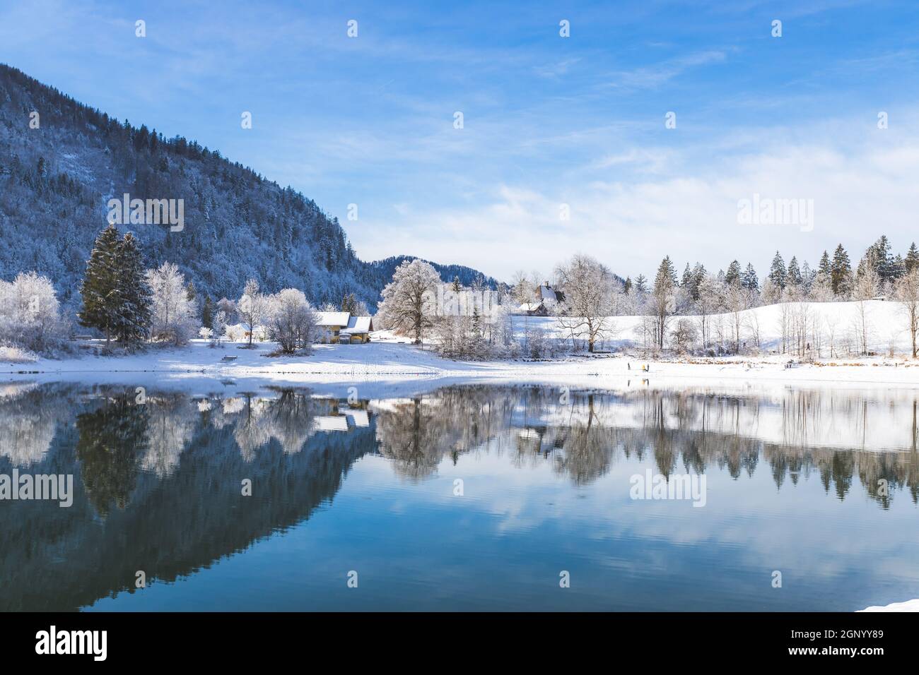 Idyllic winter landscape: Reflection lake, house and snowy trees and ...