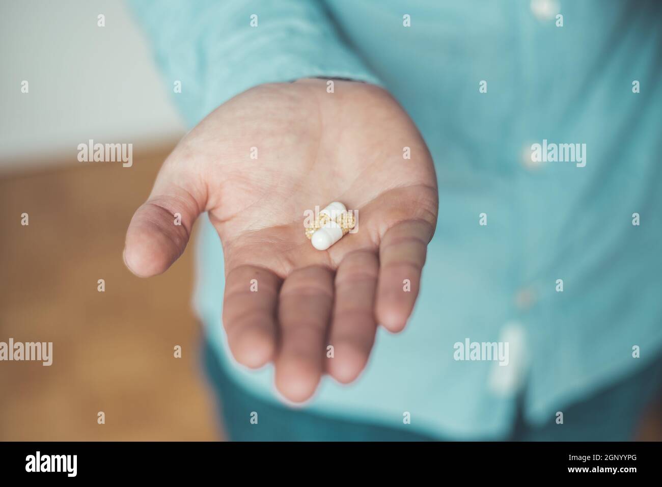 Male hand holding drug or vitamin pill in Stock Photo - Alamy