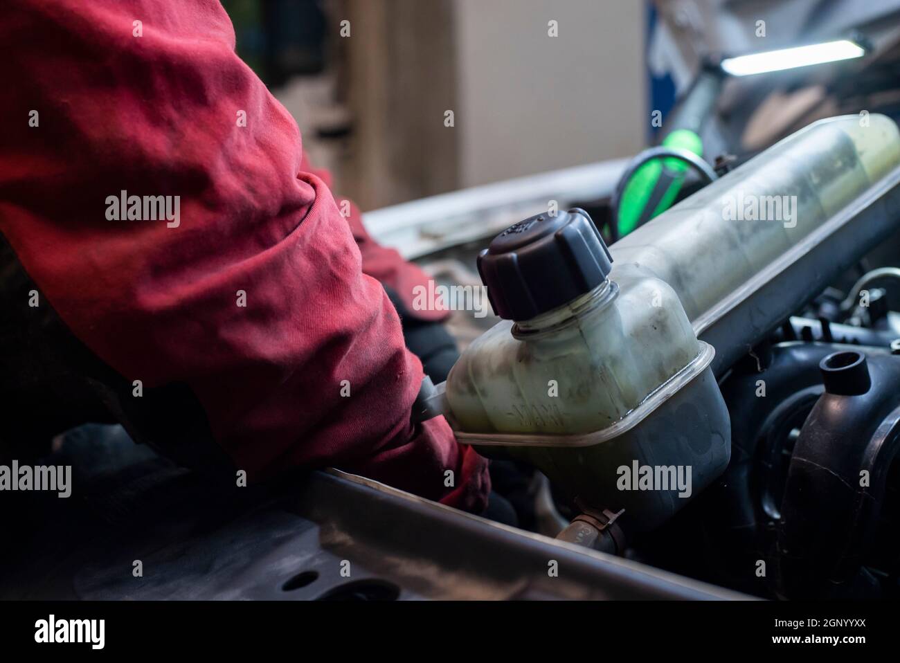 Mechanic hand at work on the engine in the workshop Stock Photo - Alamy