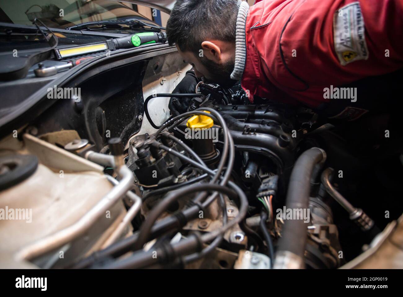 Mechanic working on the engine in the workshop Stock Photo - Alamy