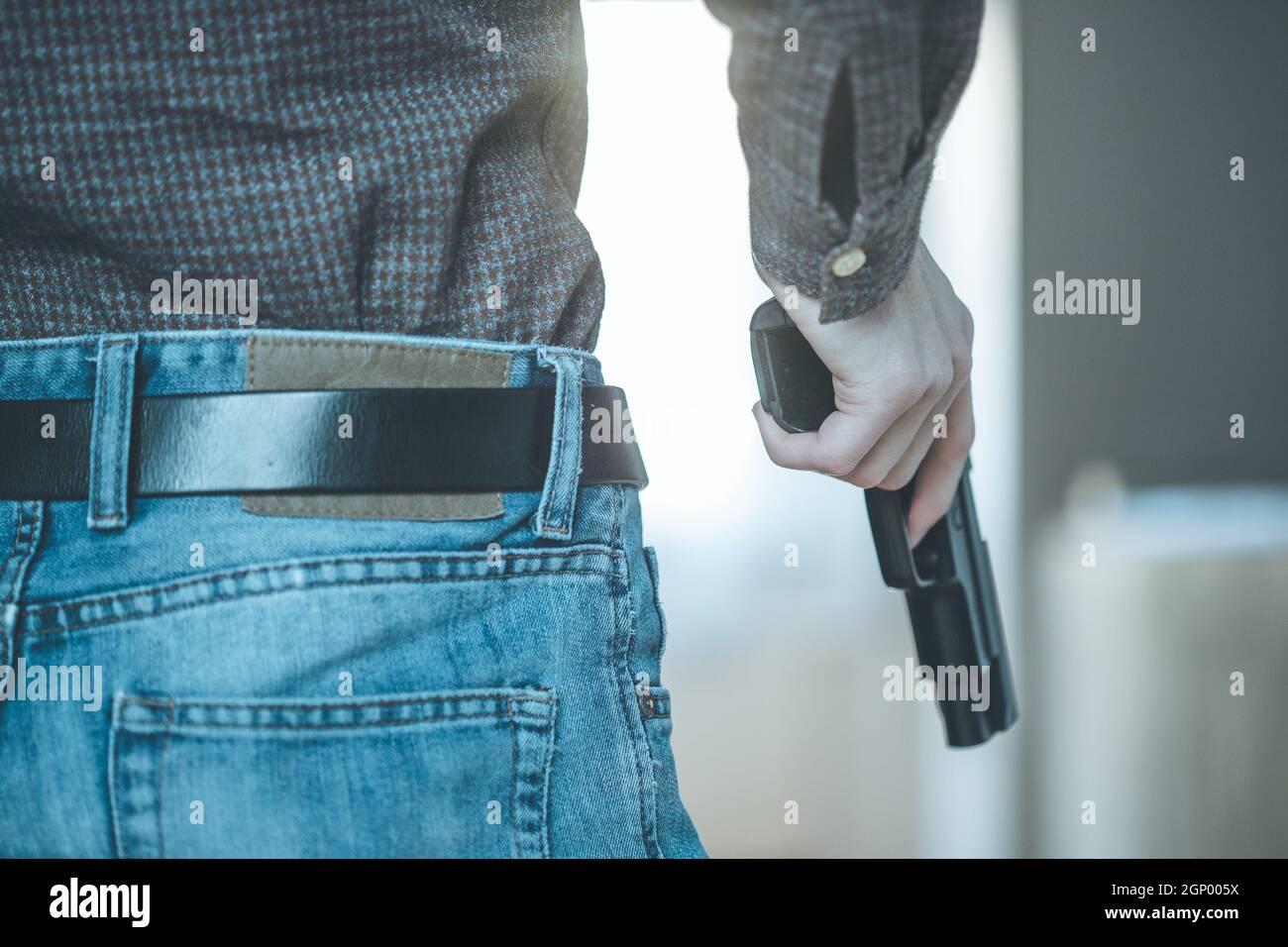 Undercover police agent is holding a black weapon in his hand, ready ...