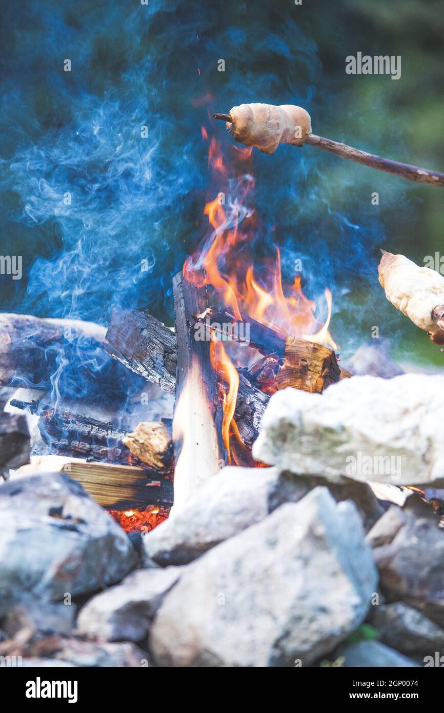 Having a barbecue on the bonfire, outdoors. Baking bread Stock Photo ...