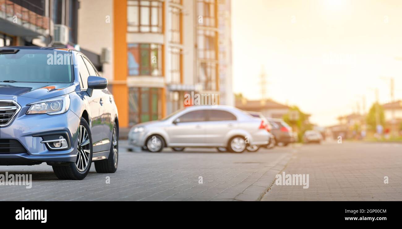Panoramic view of new shiny expensive car parked on city street side ...