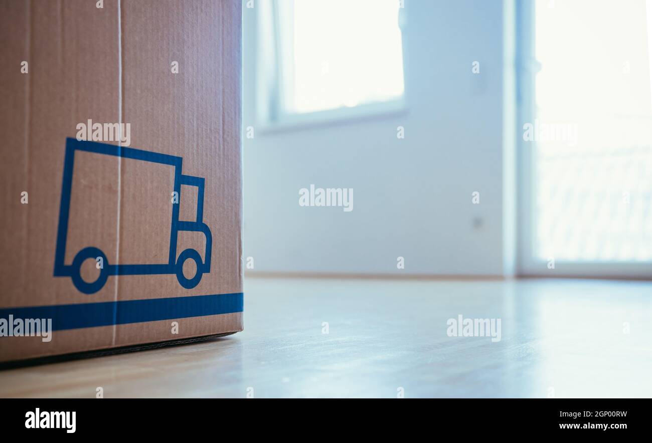 Move. Cardboard box in a clean and bright room with wooden floor ...