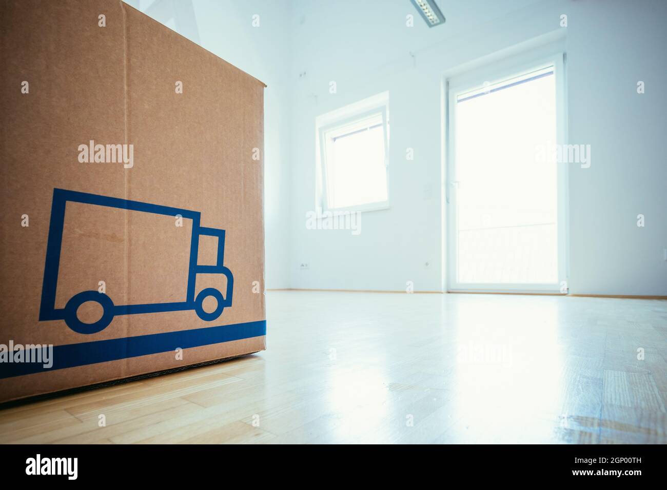 Move. Cardboard box in a clean and bright room with wooden floor ...