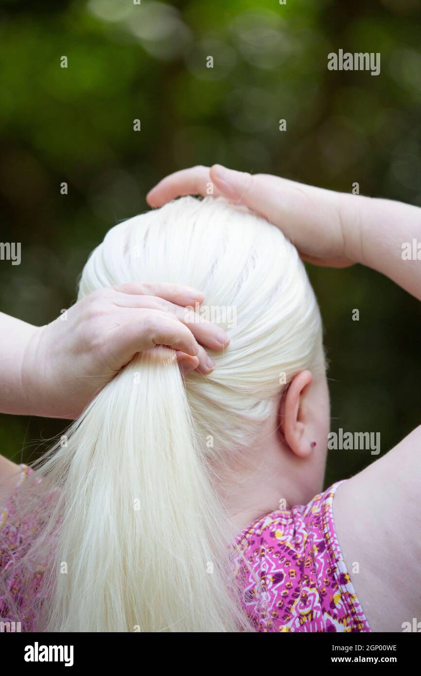 Woman gathering her long, white hair into a ponytail Stock Photo - Alamy